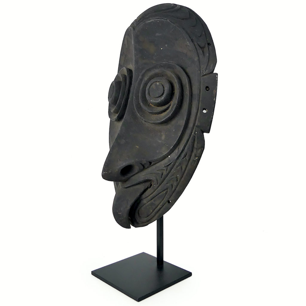 Masque ovale iatmul Moyen-Sépik en bois monochrome sur socle